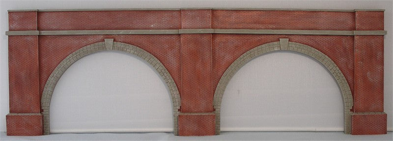 One piece casting of 2 open, narrow, low brick arches with buttresses ...